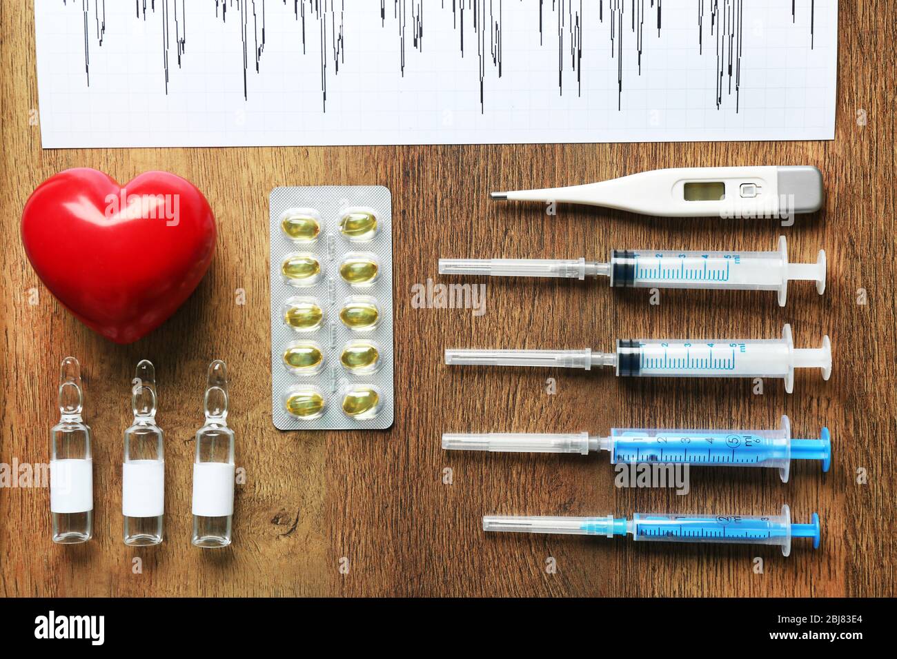Doctor table with medicines, cardiogram and red heart, top view Stock ...