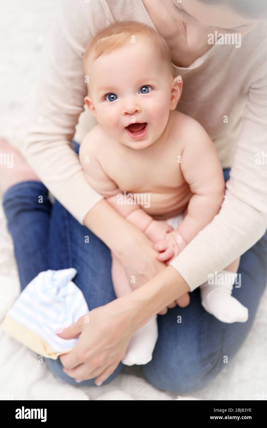 Woman dresses loving baby, close up Stock Photo - Alamy