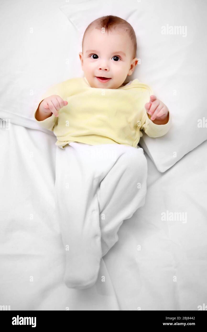 Loving baby lying on soft bed, close up Stock Photo - Alamy