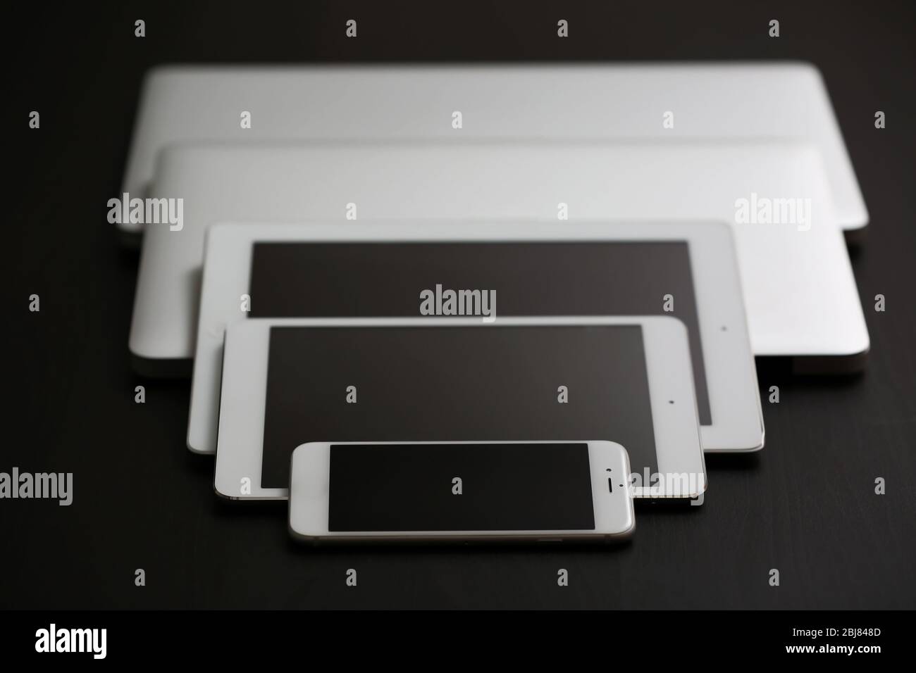 A set of electronic devices on a dark desk Stock Photo - Alamy