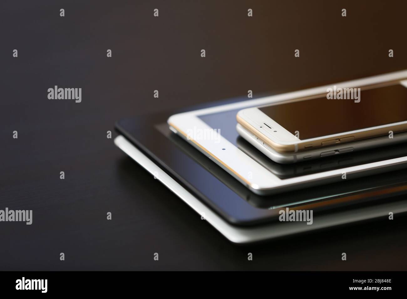 Stack of electronic devices on a dark desk Stock Photo - Alamy