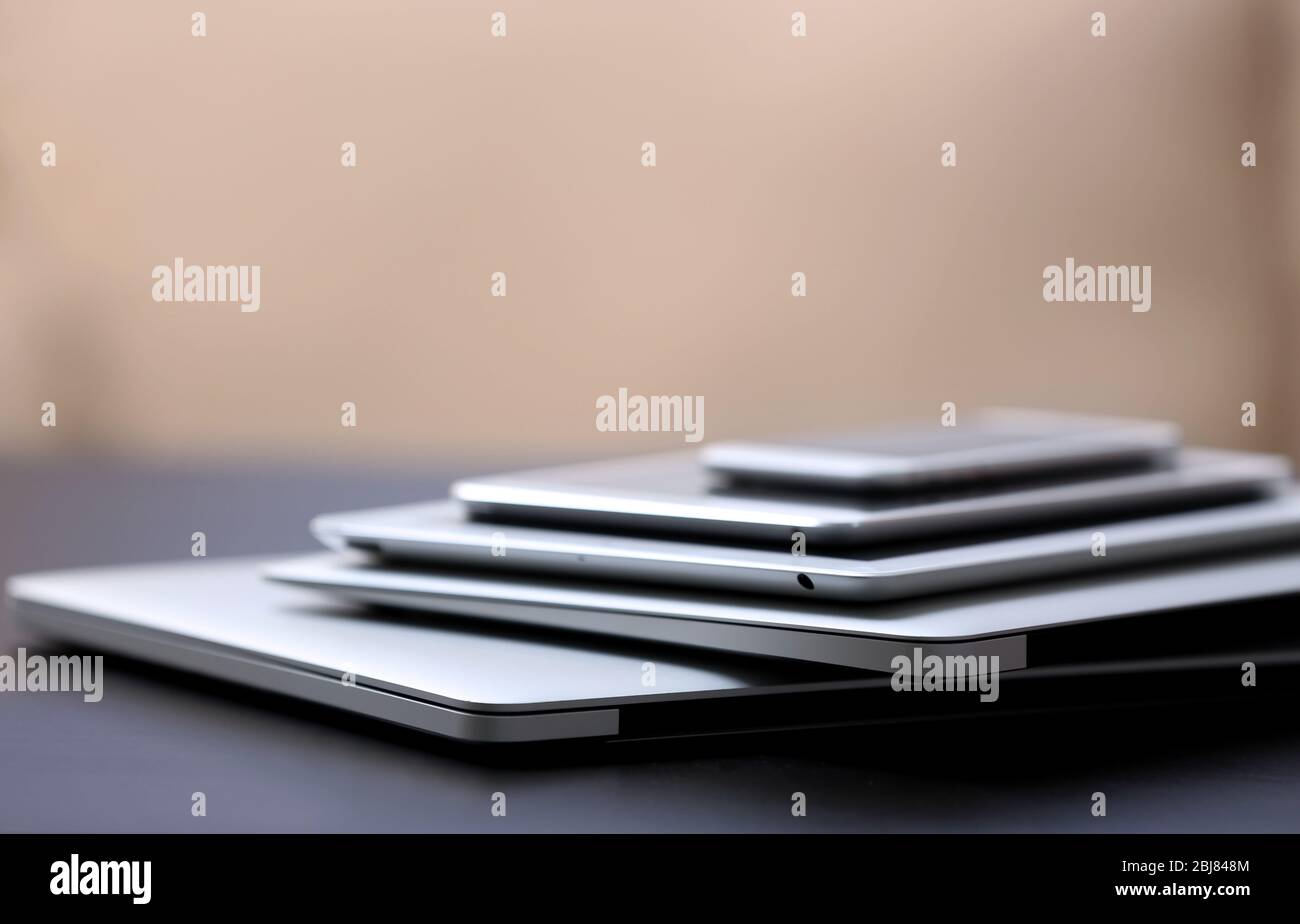 Stack of electronic devices on a dark desk Stock Photo - Alamy