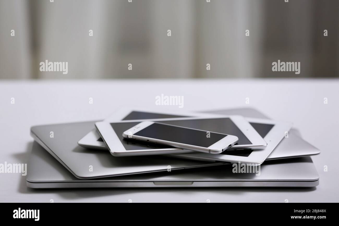 Stack of electronic devices on a white desk Stock Photo - Alamy