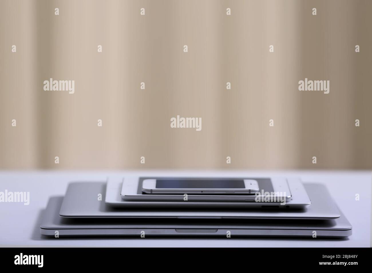 Stack of electronic devices on a white desk Stock Photo - Alamy
