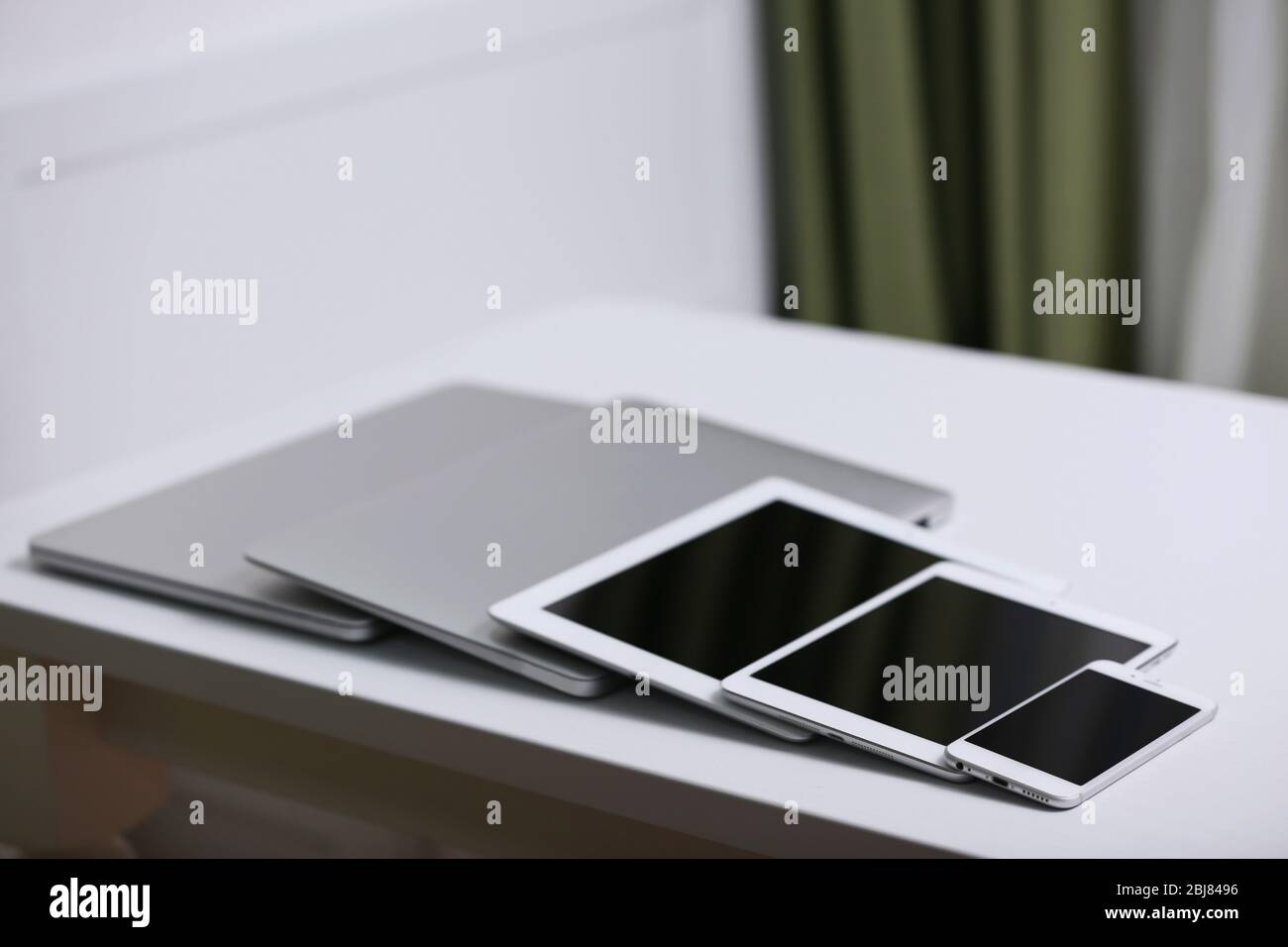 A set of electronic devices on a white desk Stock Photo - Alamy