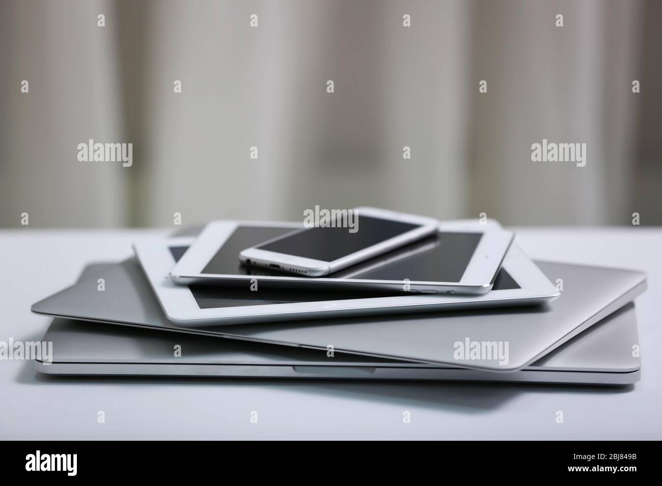Stack of electronic devices on a white desk Stock Photo - Alamy