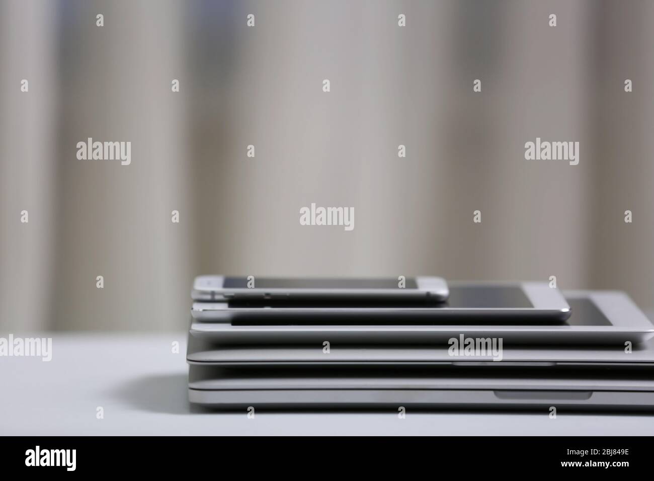 Stack of electronic devices on a white desk Stock Photo - Alamy