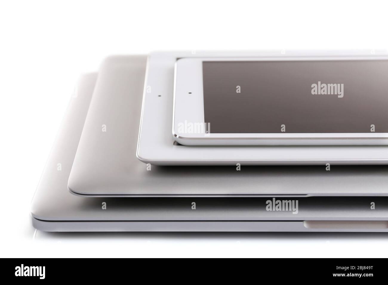Stack of electronic devices on a white desk Stock Photo - Alamy