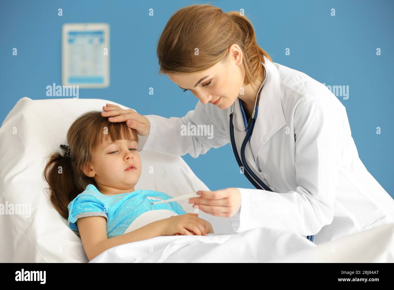 Doctor checking little girl's temperature with a thermometer Stock ...