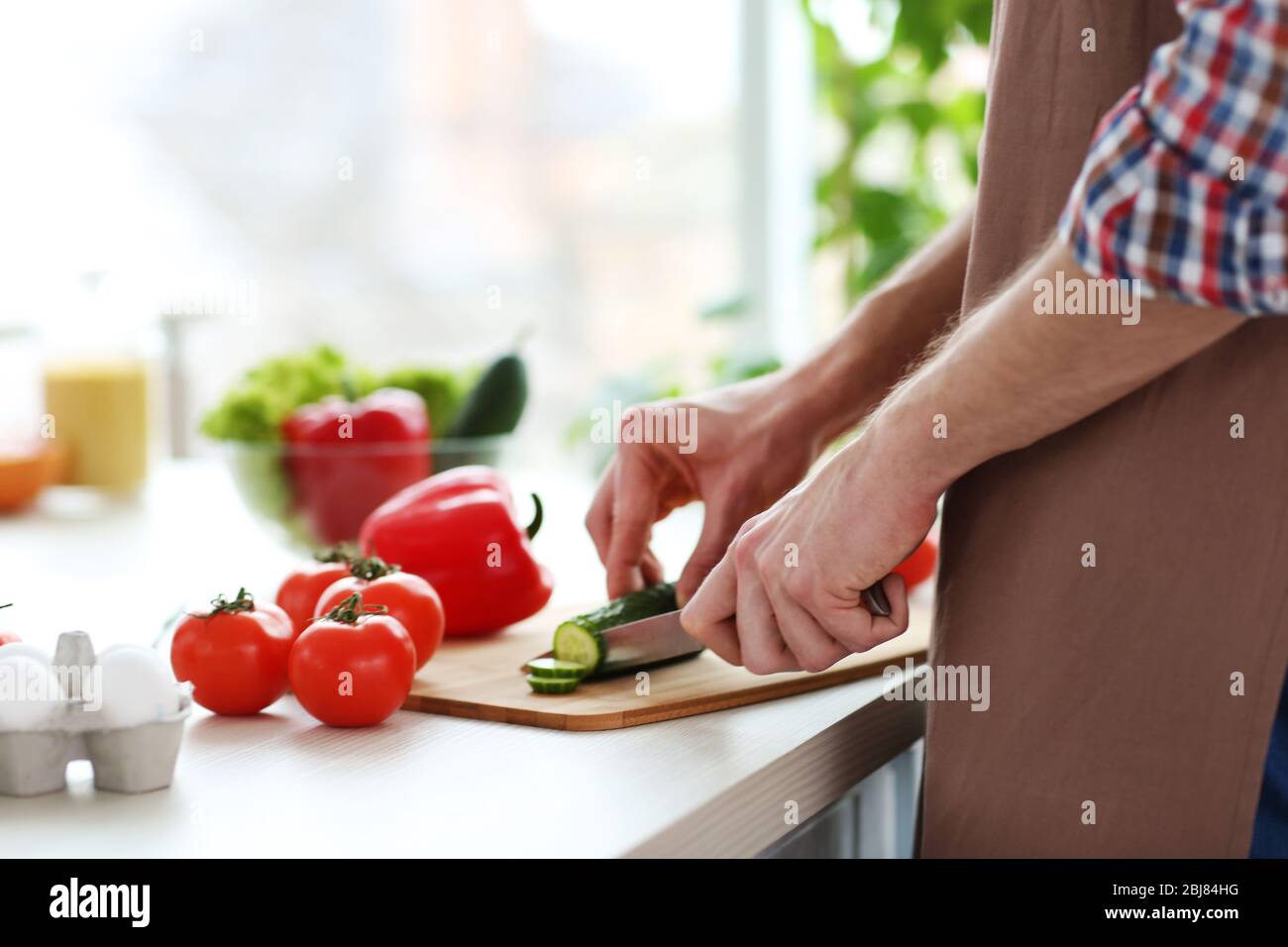 Man chopping vegetables in kitchen Stock Photo - Alamy