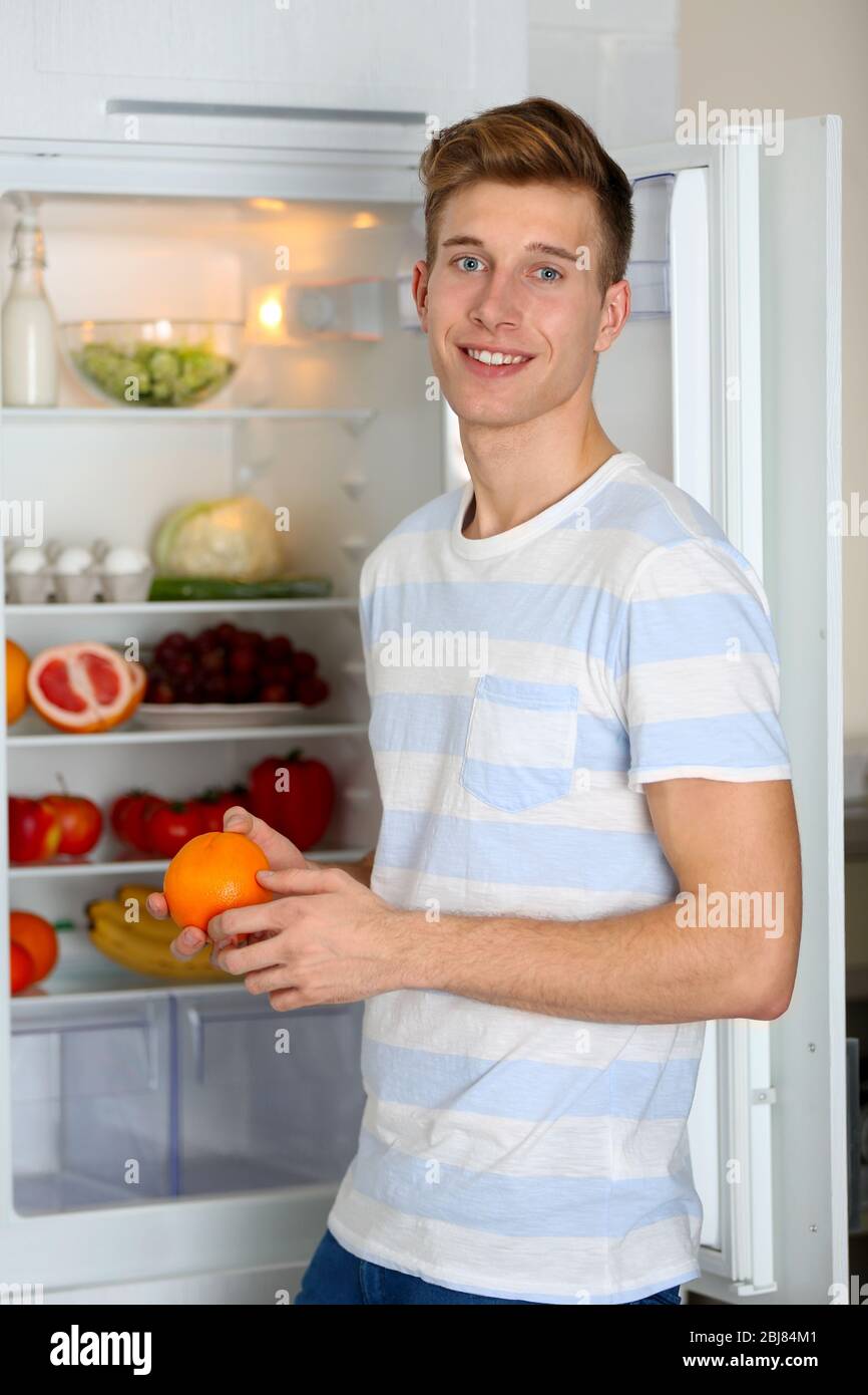 Handsome man taking food from refrigerator Stock Photo - Alamy