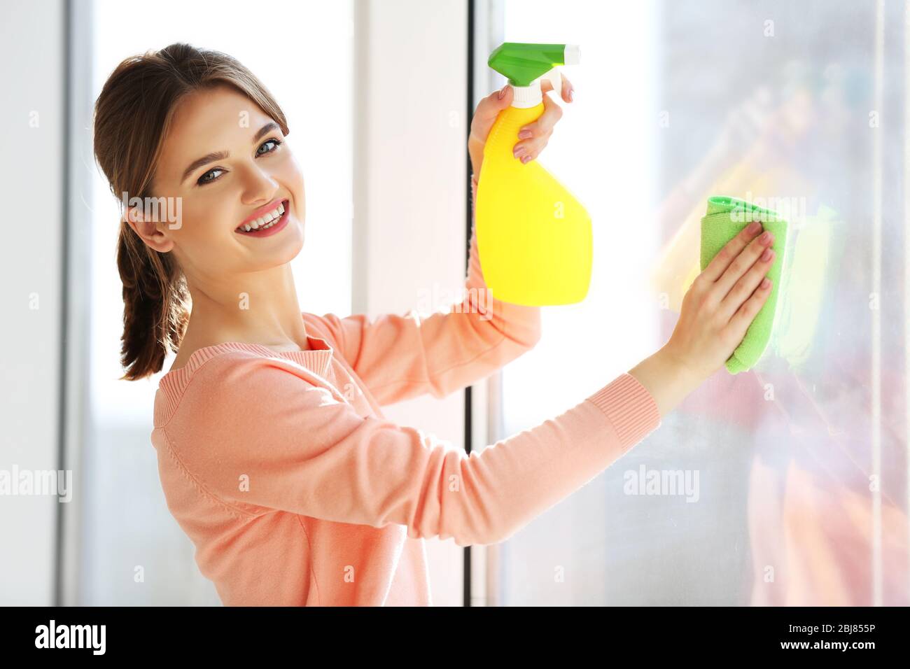 Cleaning concept. Young woman washing window, close up Stock Photo - Alamy