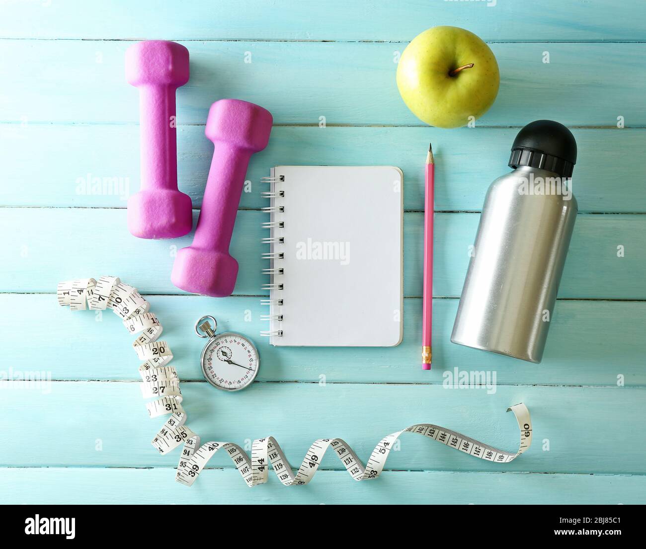 Athlete's set with equipment, notebook and bottle of water and apple on ...