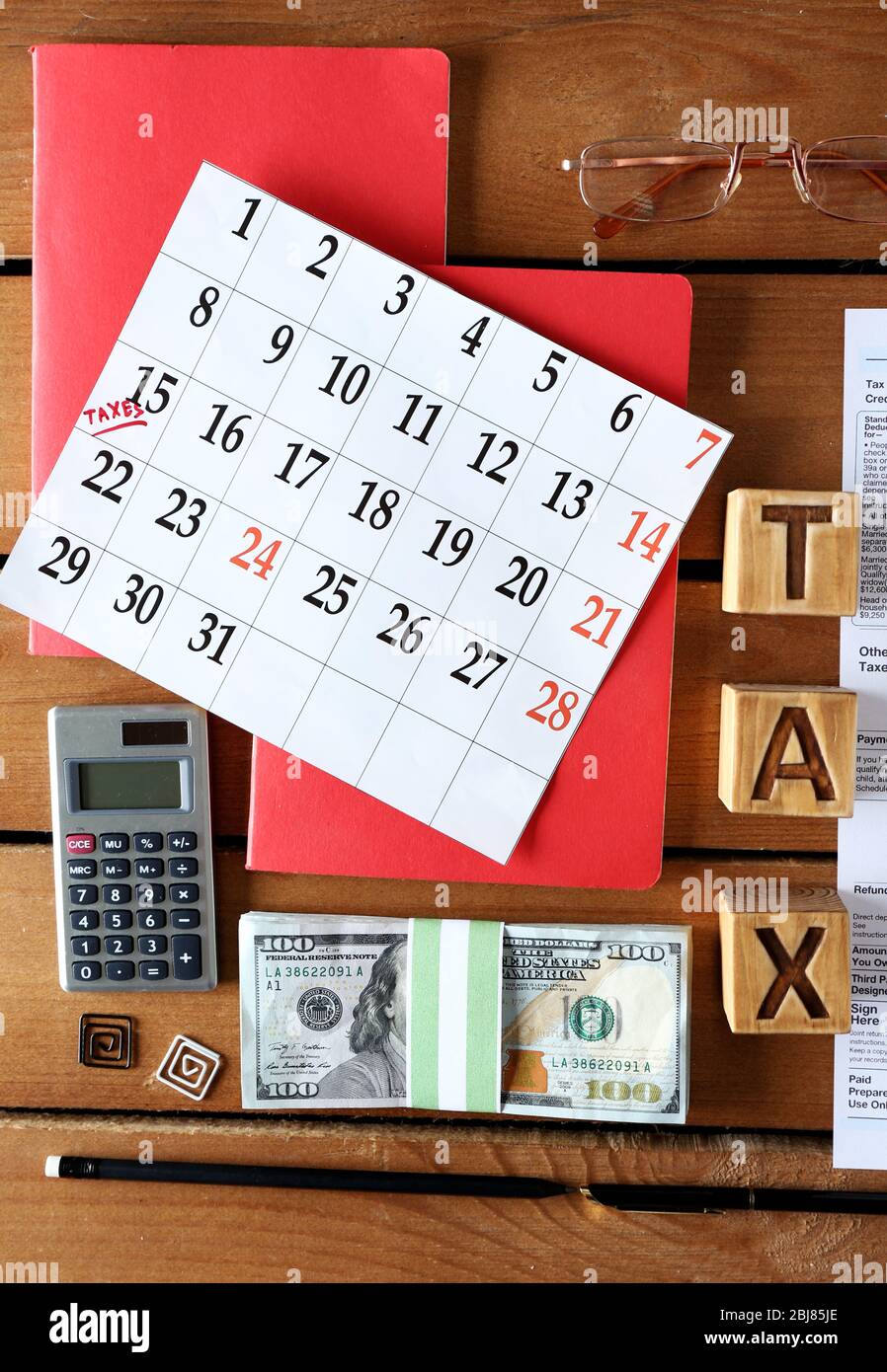Calculator, notebooks, calendar and money banknotes on wooden ...