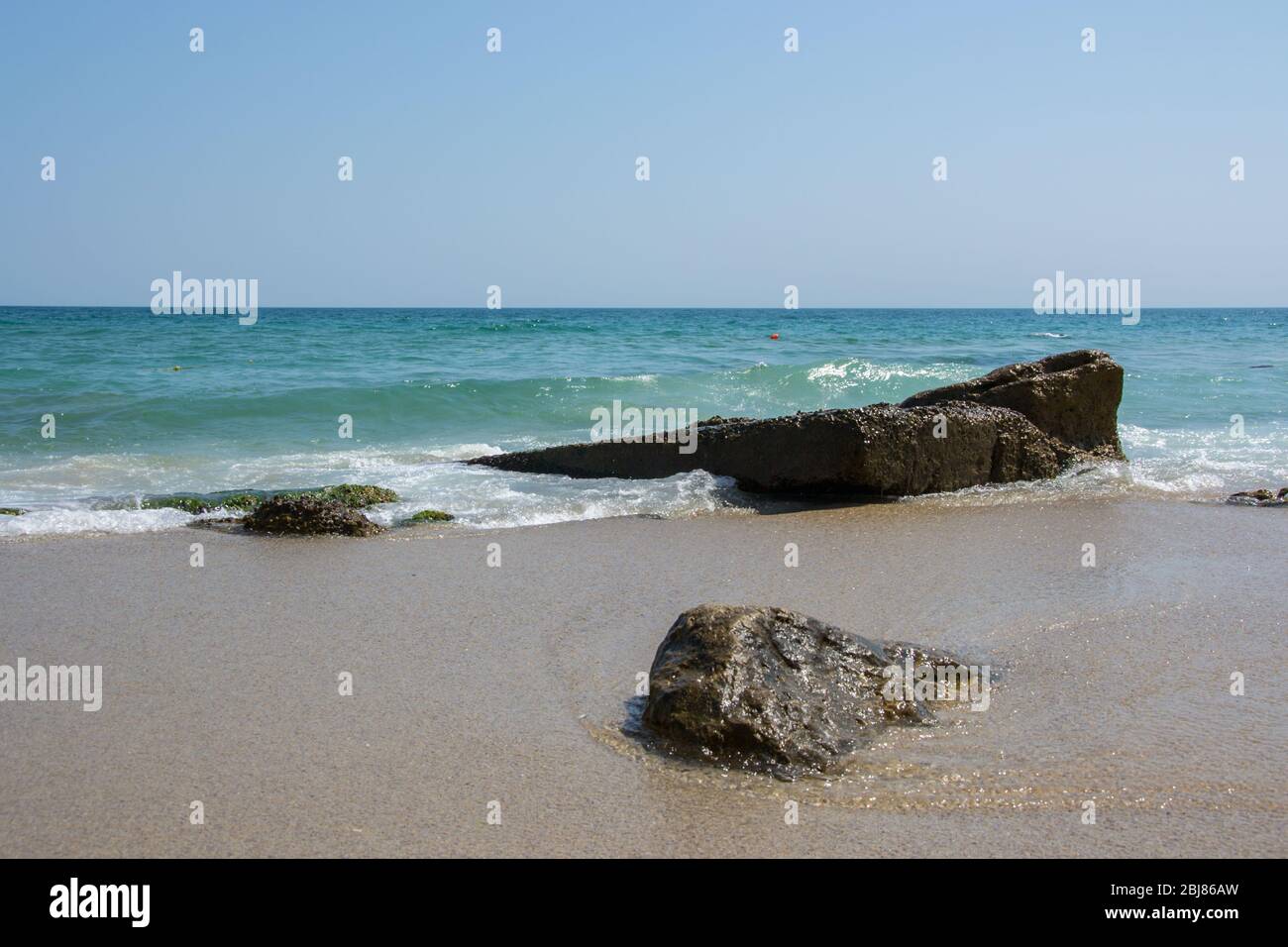 Beautiful wild beach landscape, sunny day, water waves hitting the ...