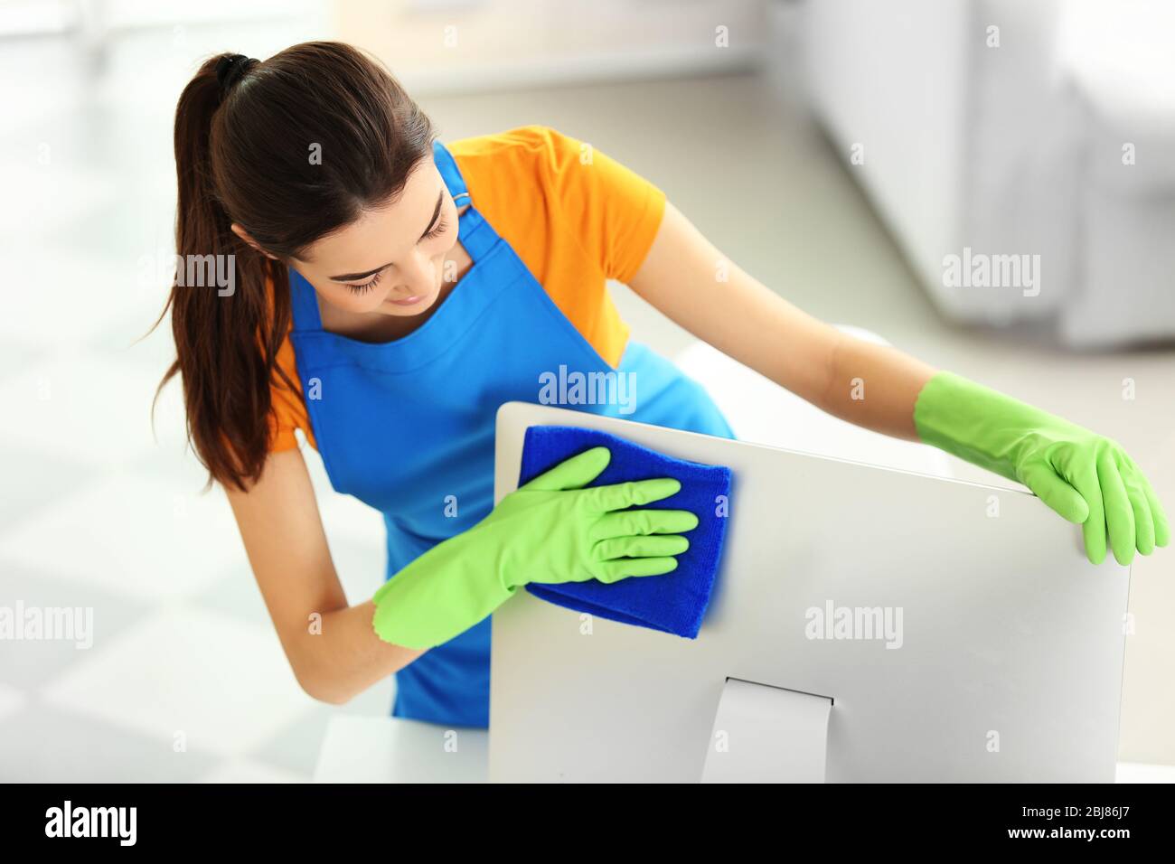 Young woman cleaning computer monitor in the office Stock Photo - Alamy