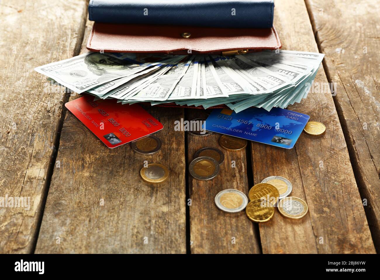 Leather wallets with money and credit cards on wooden table Stock Photo - Alamy