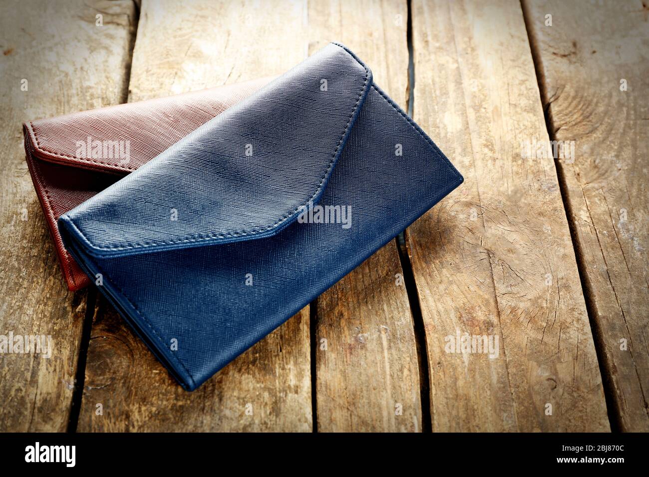Leather wallets on wooden table Stock Photo - Alamy