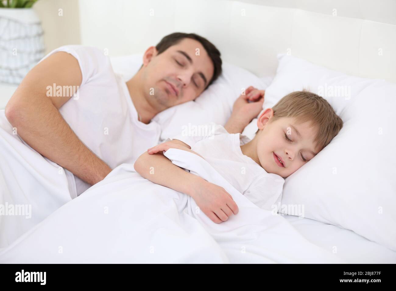 Father and son sleeping in bed at home Stock Photo - Alamy