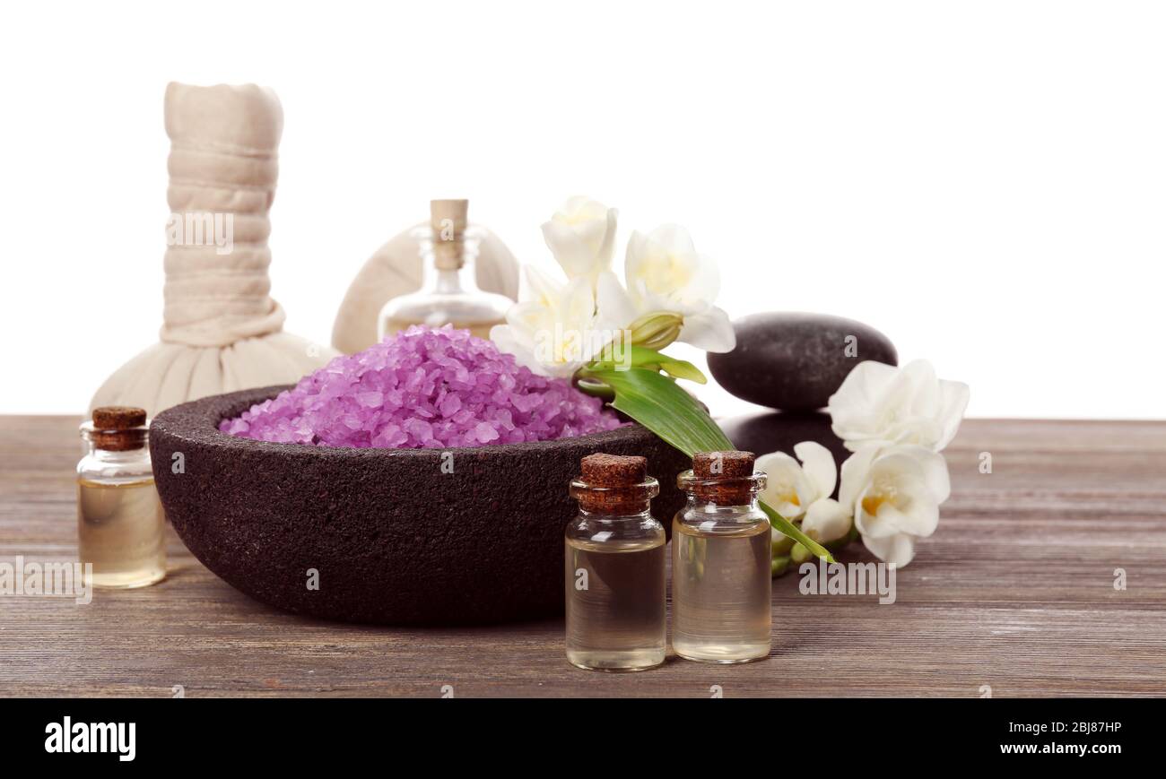 Spa composition with sea salt in a bowl, massage balls and flowers on ...