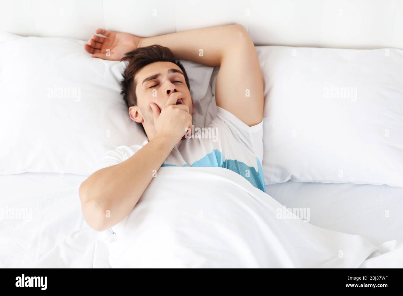 Morning concept. Yawned man in the bed Stock Photo - Alamy
