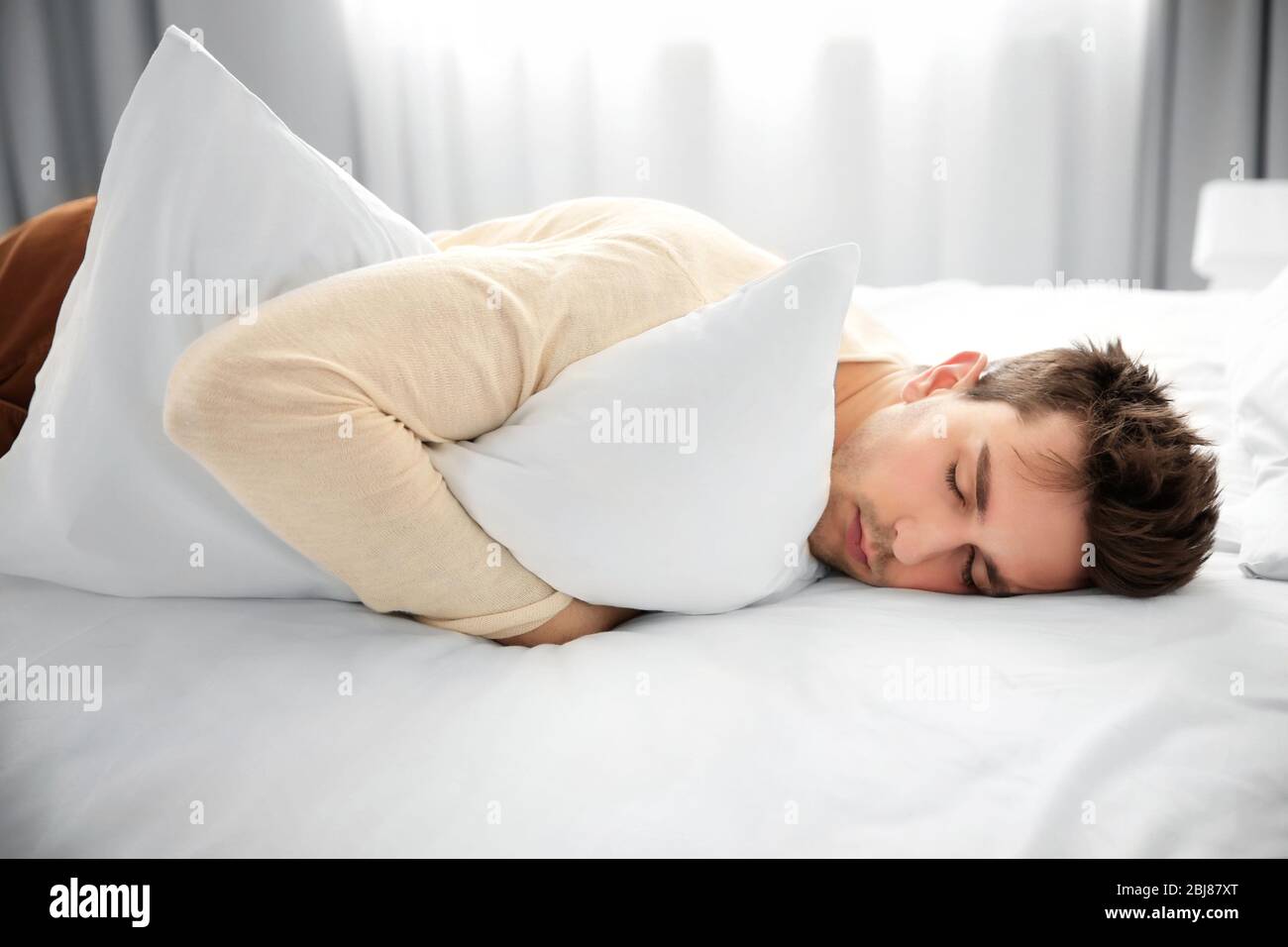 Dressed man sleeping on the bed Stock Photo - Alamy