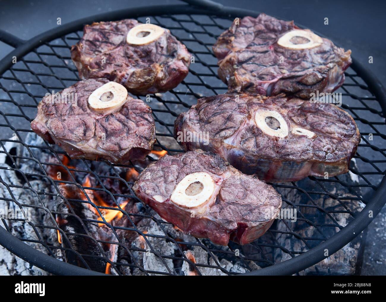 Beef shanks on a barbecue grill over coals. View from above Stock Photo ...