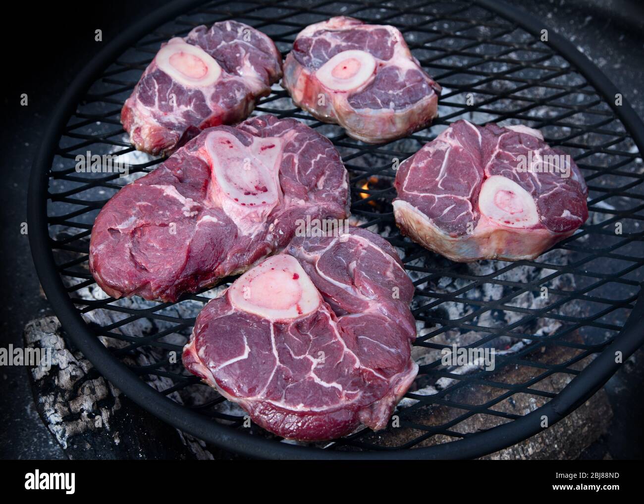 Beef shanks on a barbecue grill over coals. View from above Stock Photo ...