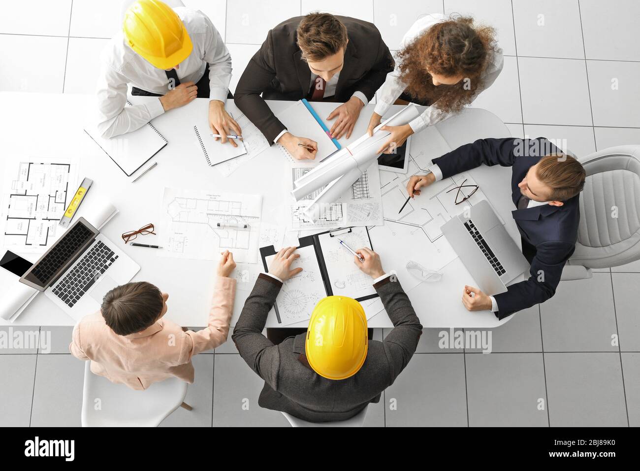 Team of professional engineers working with blueprints Stock Photo - Alamy