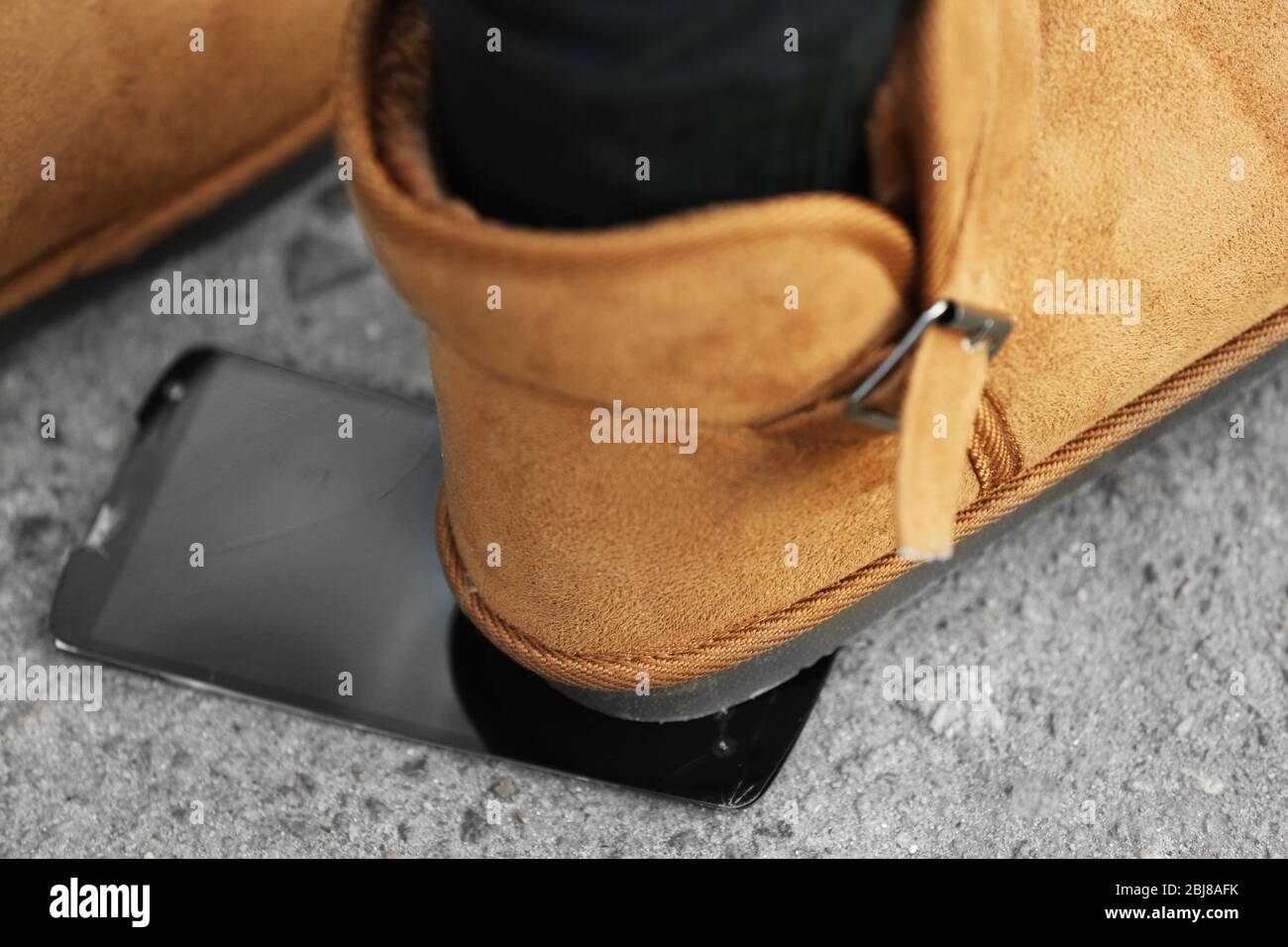 Female boots crushing a mobile phone on the pavement Stock Photo - Alamy