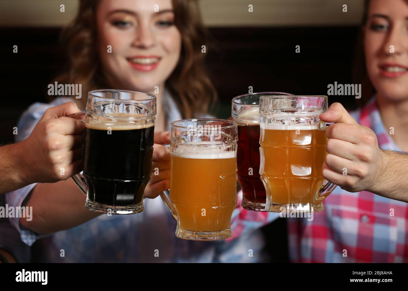 Beautiful girls and their friends drinking beer in pub Stock Photo - Alamy