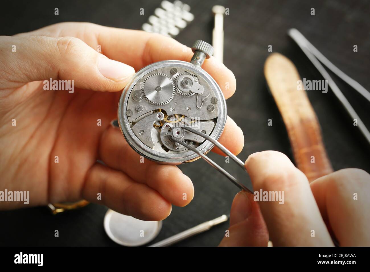 Watchmaker hands repairing mechanism of old watch closeup Stock Photo ...