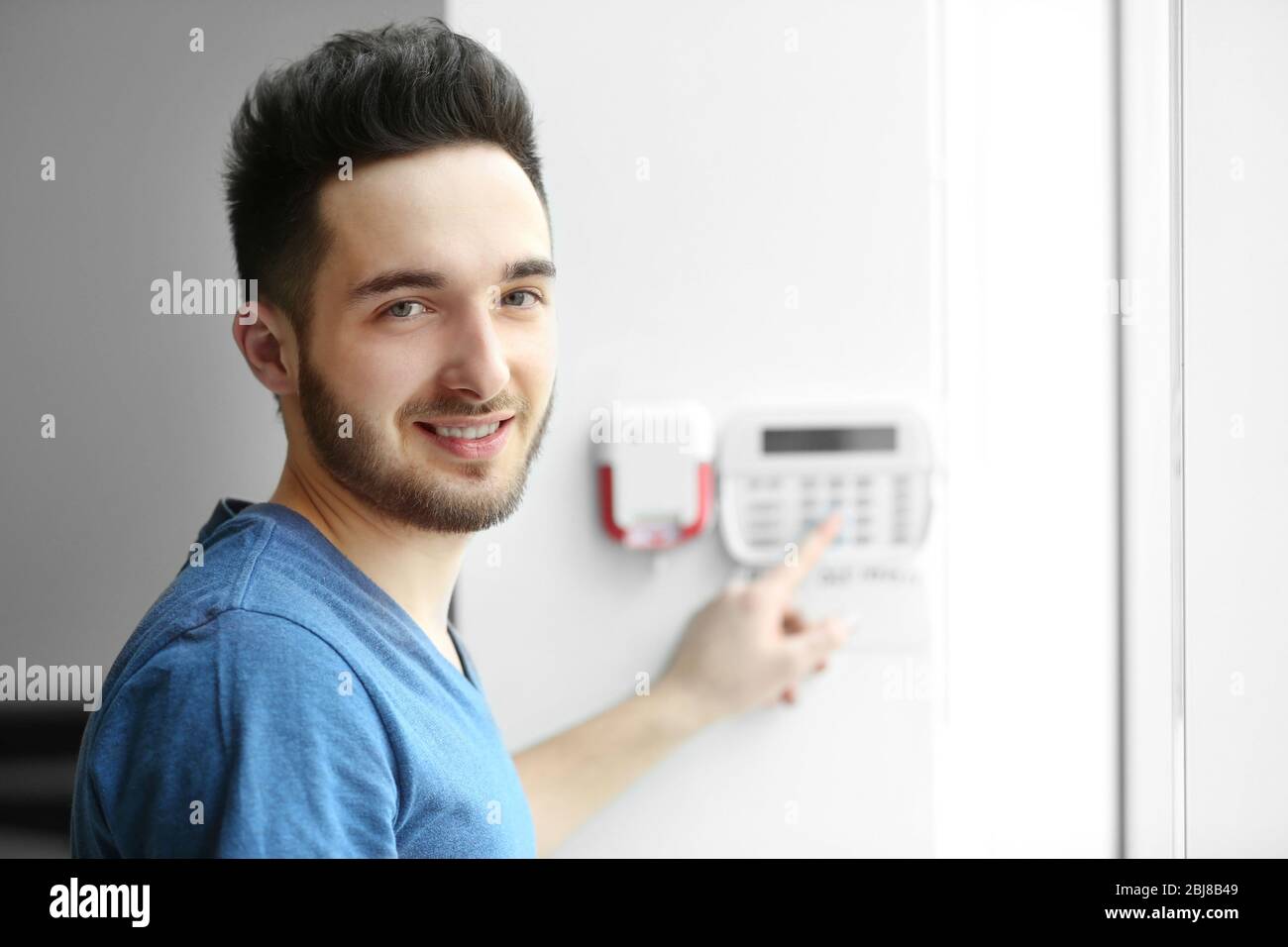 Man entering code on security system keypad indoors Stock Photo - Alamy