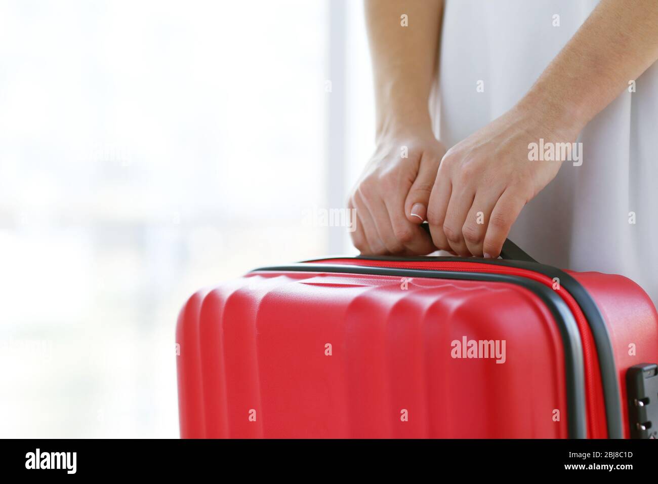 Woman in white dress holding a large red suitcase, close up Stock Photo ...
