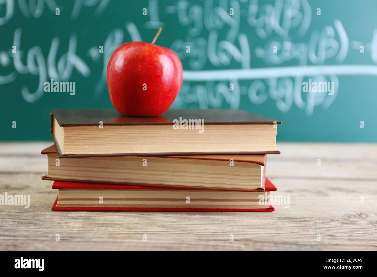 Few books with red apple on table Stock Photo - Alamy