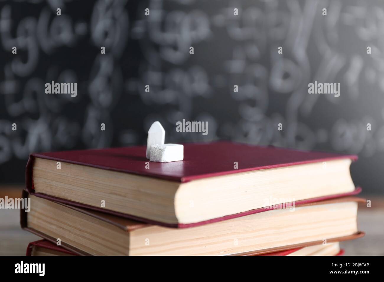 Few books with chalk on table Stock Photo - Alamy