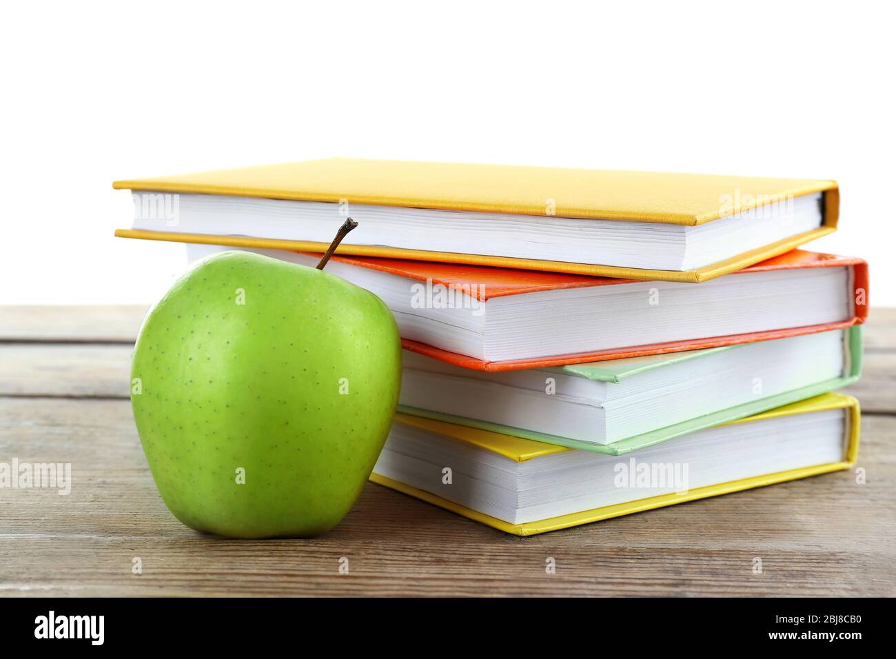 Few books with green apple on table Stock Photo - Alamy