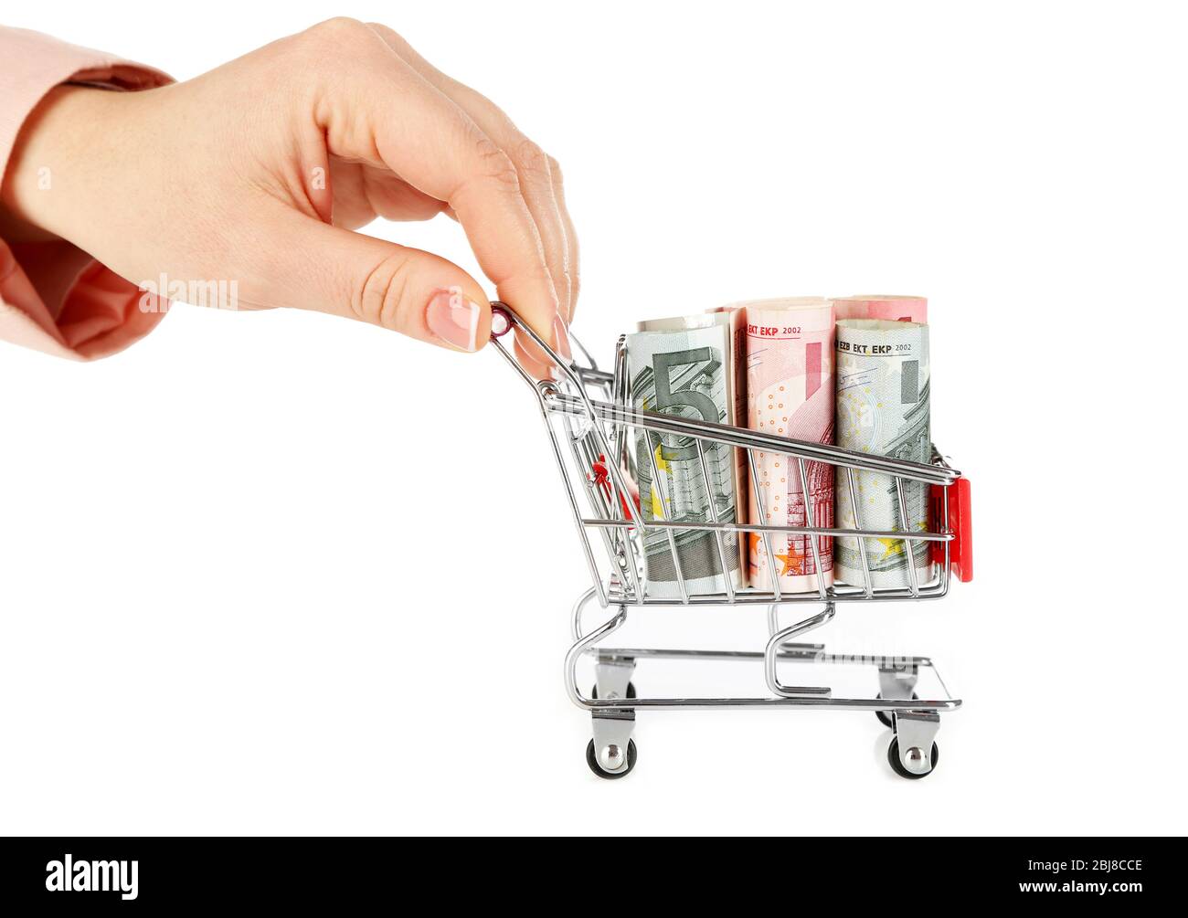 Woman holding supermarket trolley full of money, isolated on white ...