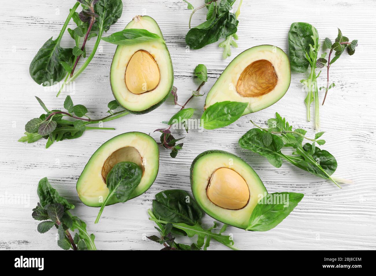 Avocado on a light wooden background Stock Photo - Alamy