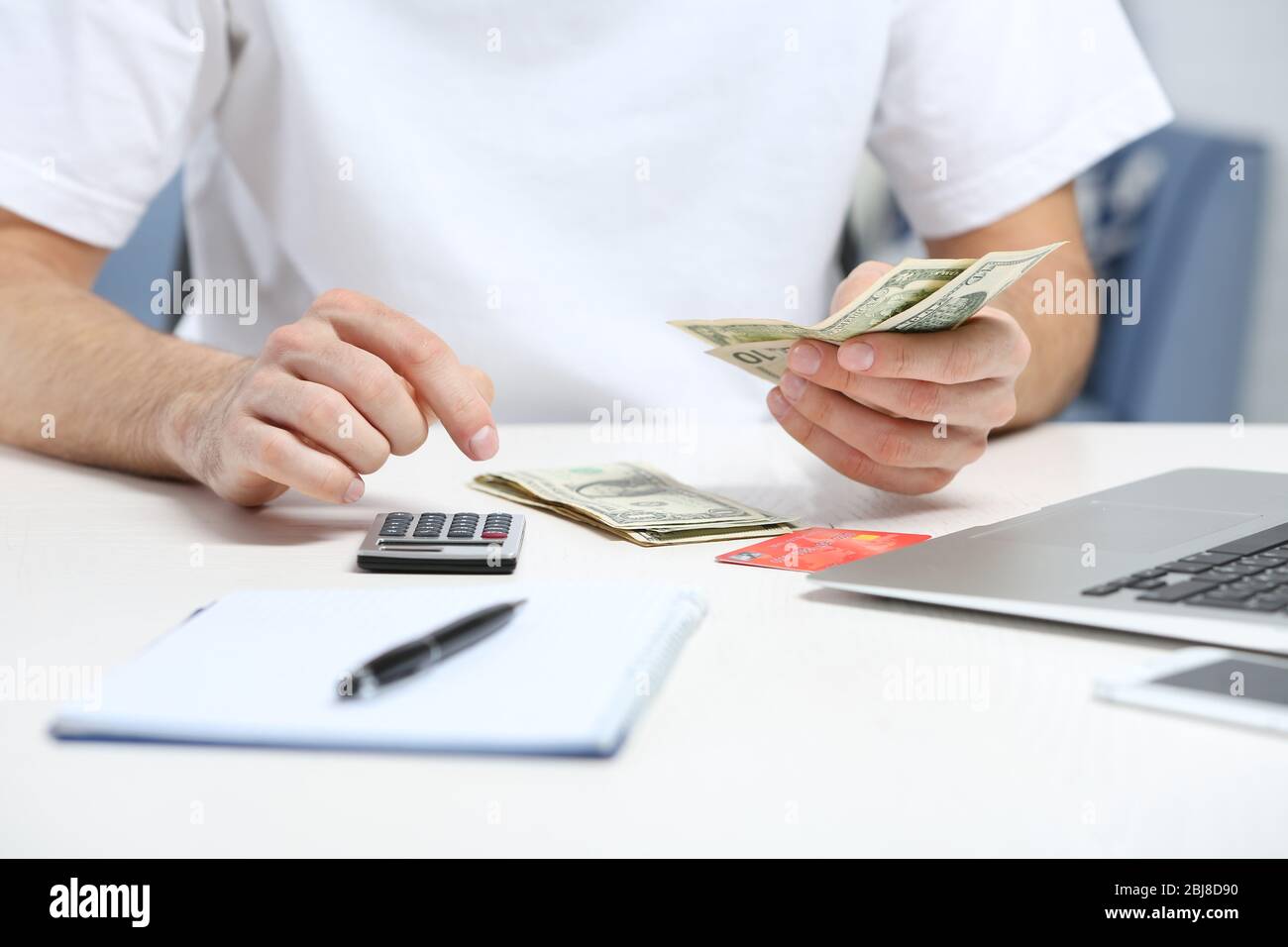 Man counting money and making calculations Stock Photo - Alamy