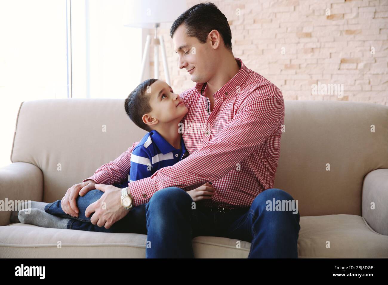 Father and son looking at each other indoors Stock Photo - Alamy