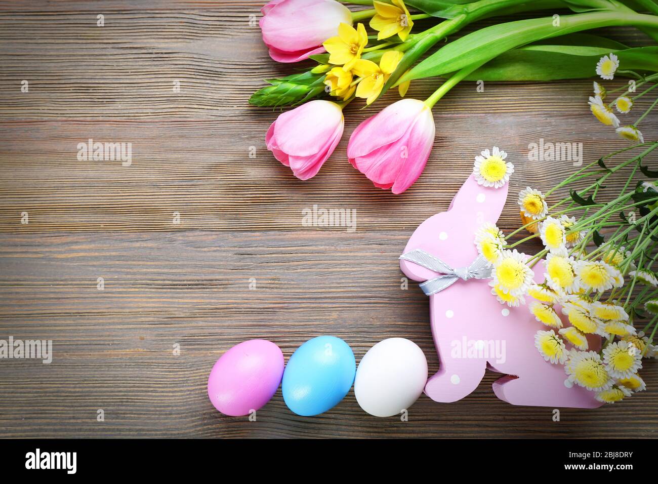 Easter eggs with spring flowers and rabbit on wooden background Stock ...