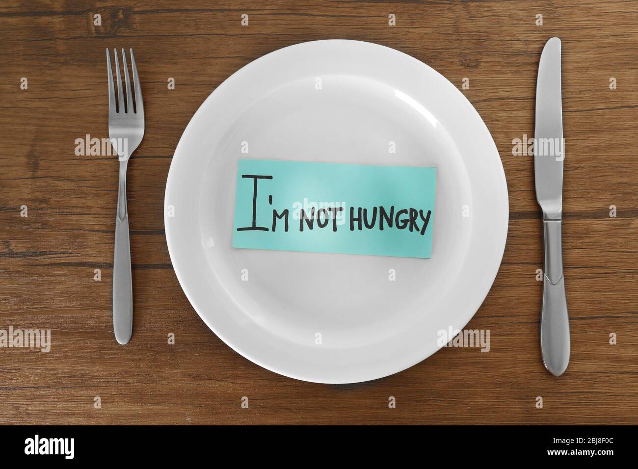 White plate with words I'm not hungry on wooden background Stock Photo ...