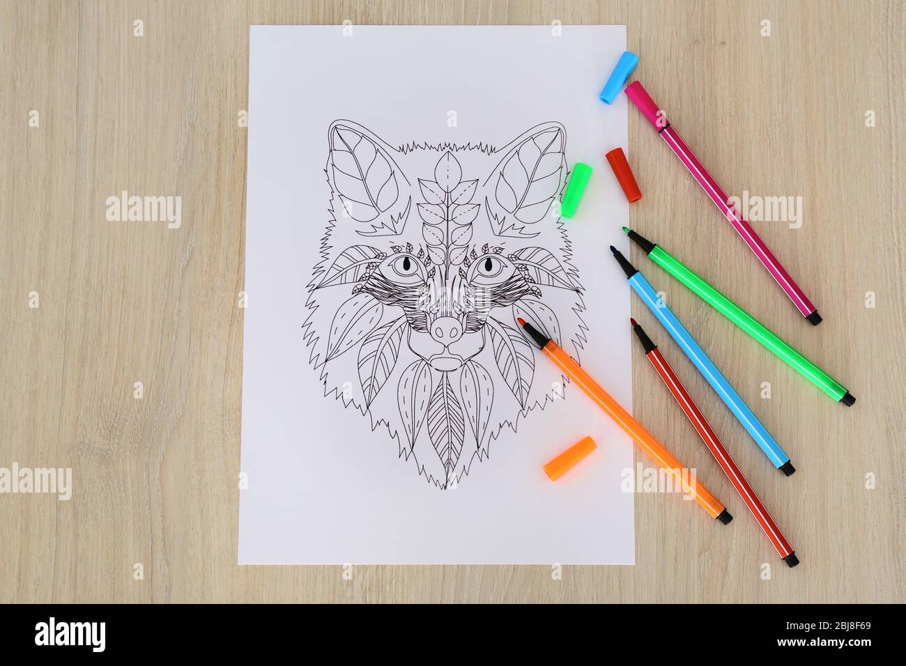 Adult anti stress coloring and soft tip pencils on wooden table, top ...