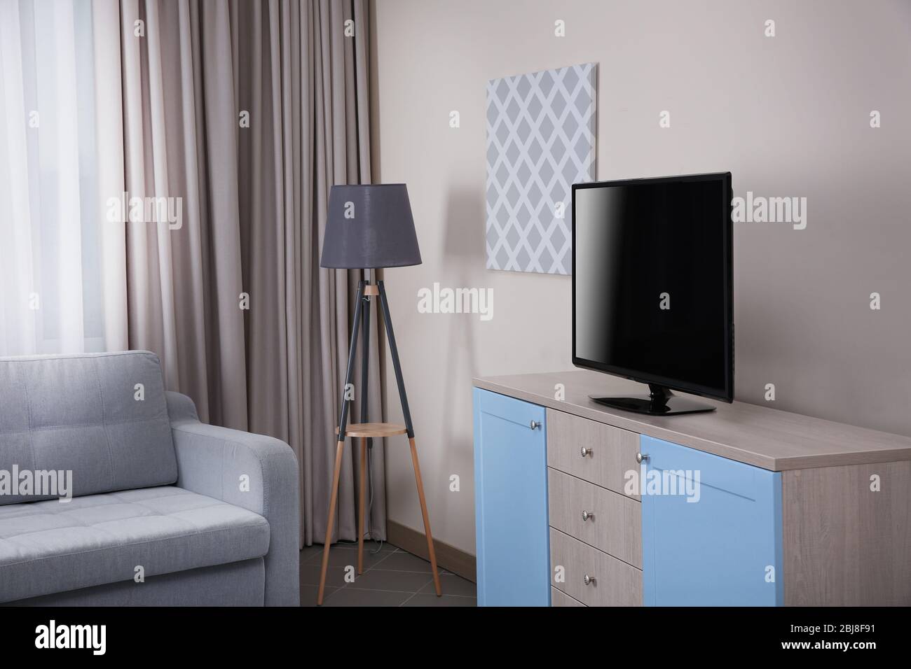 Modern living room with couch and TV Stock Photo - Alamy