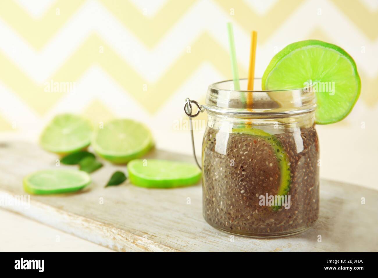 Chia seeds beverage with lime in glass jar on striped background Stock ...