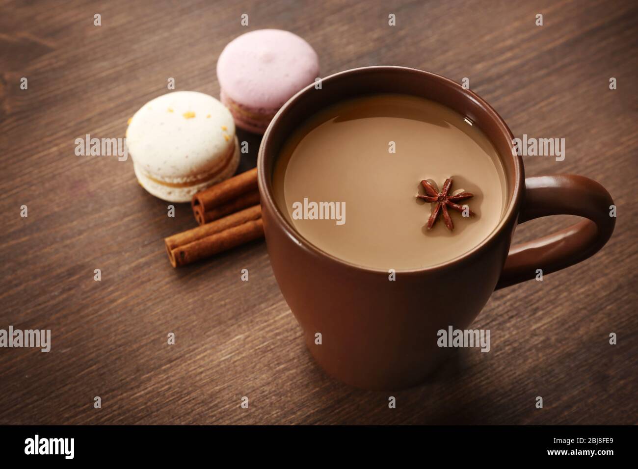 Milk tea with spices on wooden background Stock Photo - Alamy