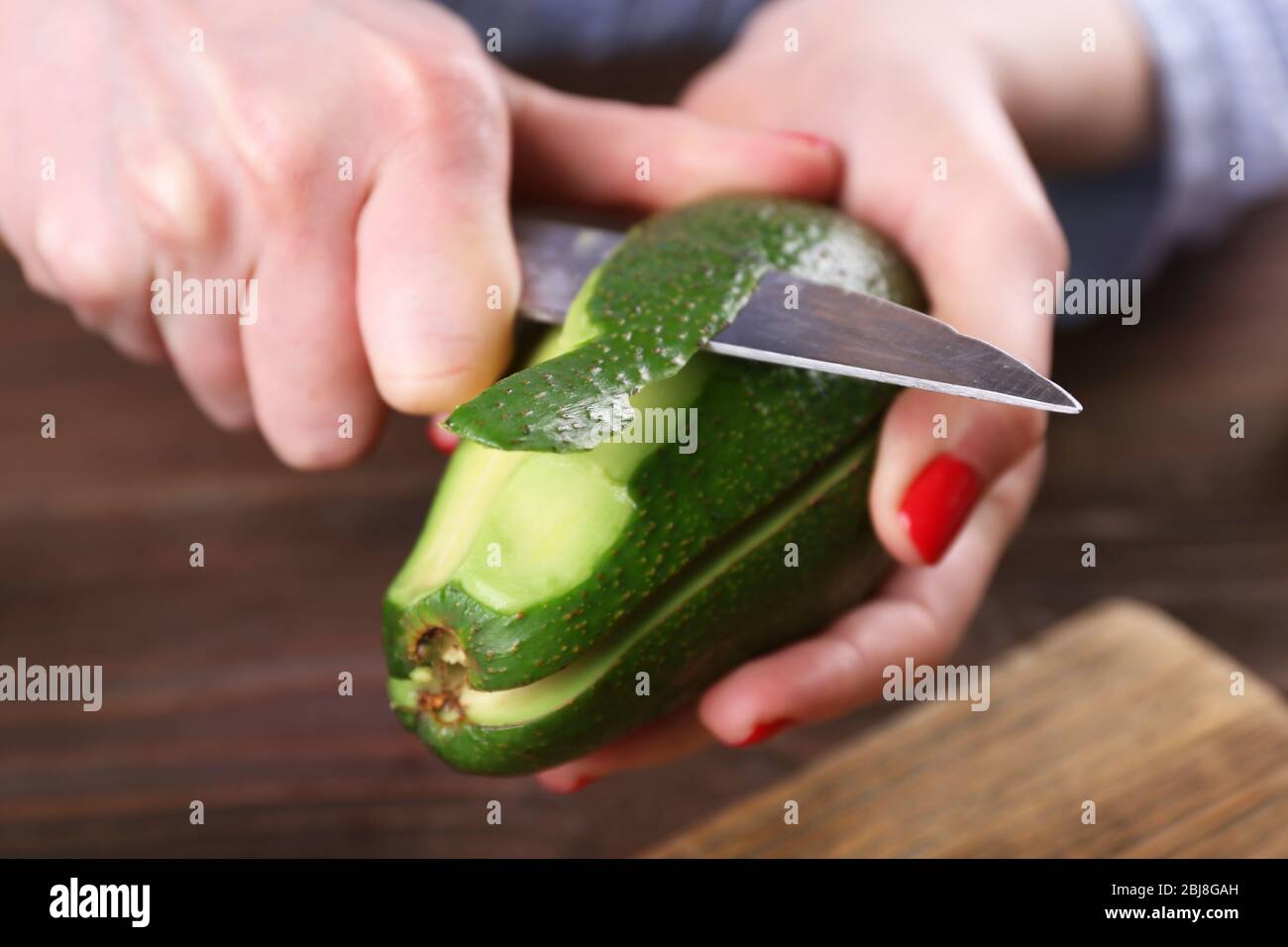 Female hands peeling an avocado, close up Stock Photo - Alamy