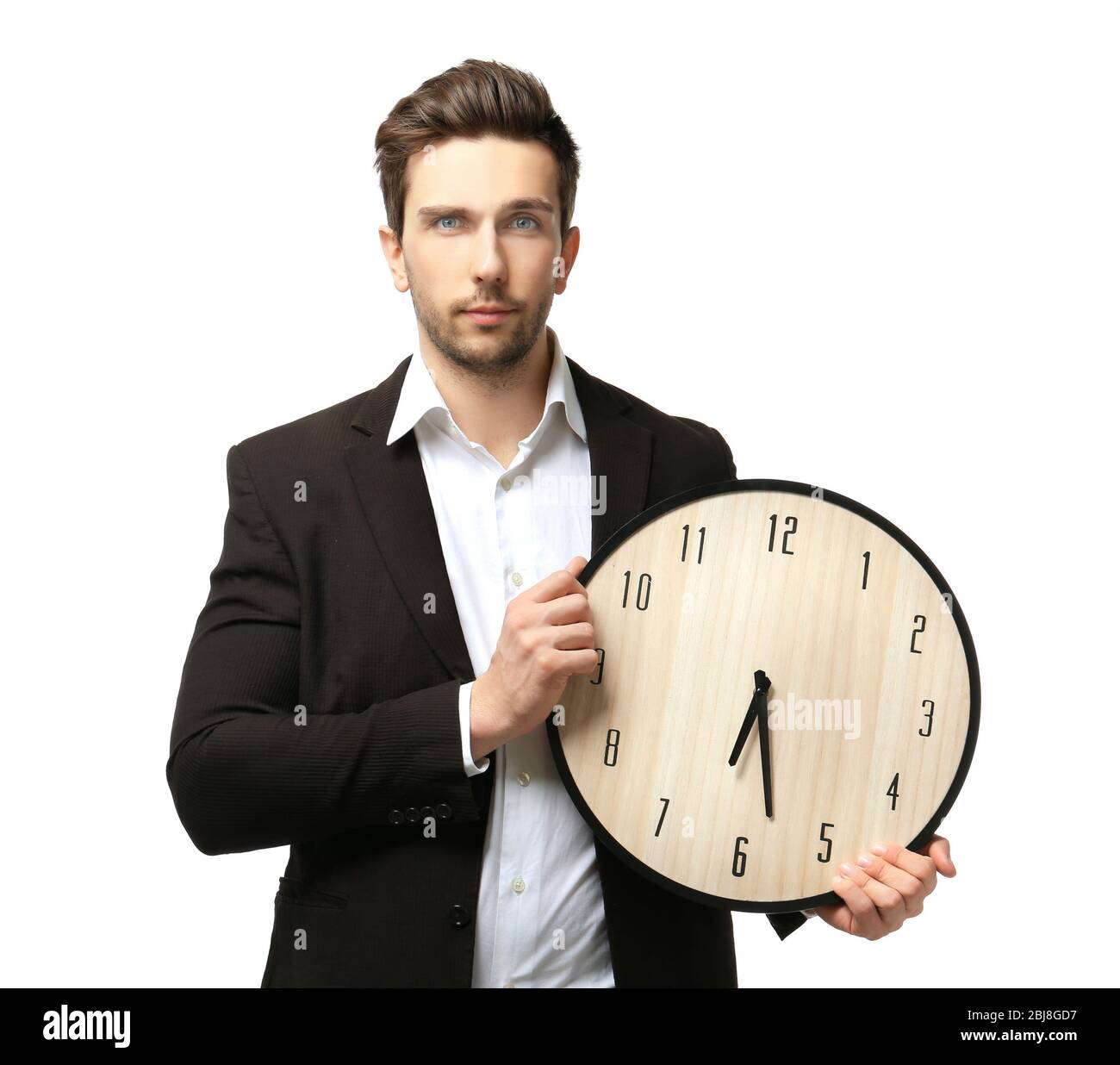 Man in black suit holding big clock on white background Stock Photo - Alamy