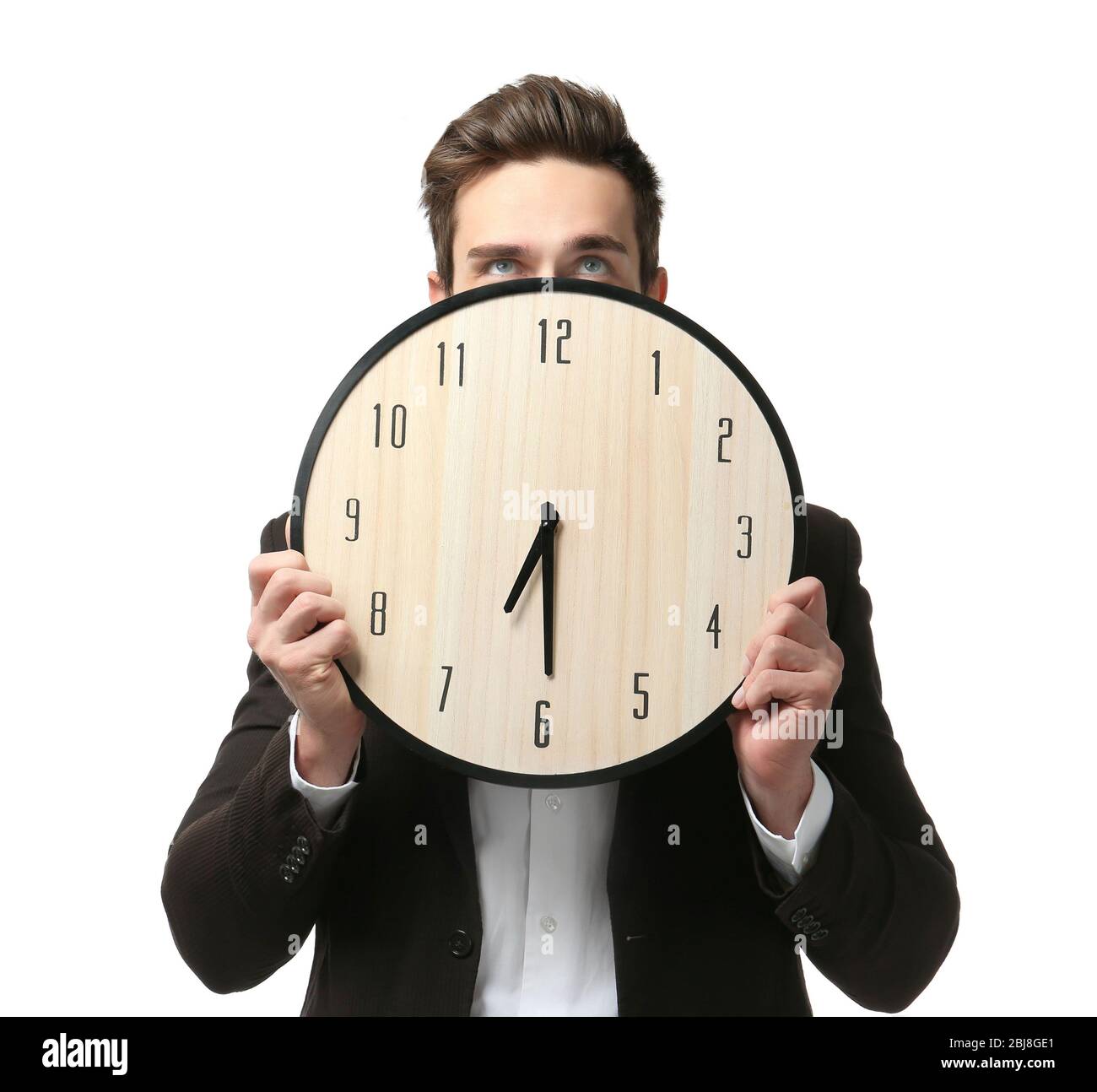 Man in black suit holding big clock on white background Stock Photo - Alamy